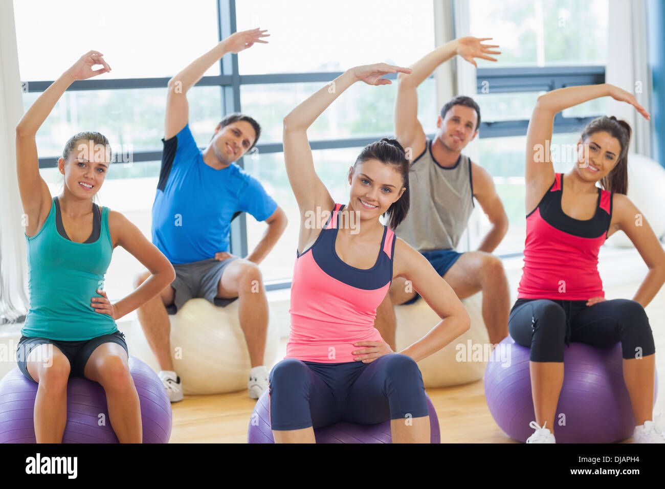 People stretching hands on exercise balls at gym Stock Photo - Alamy