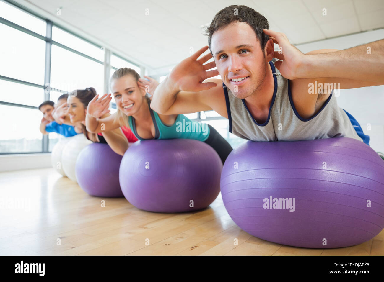 Portrait of class exercising on fitness balls in a row Stock Photo - Alamy