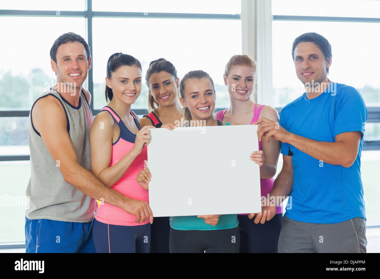 Portrait of a group of fitness class holding blank paper Stock Photo ...