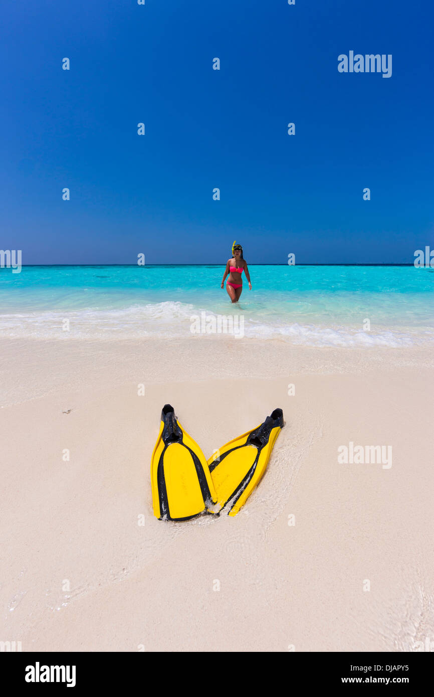 Woman emerging from the sea, flippers on the beach at front, Indian ...