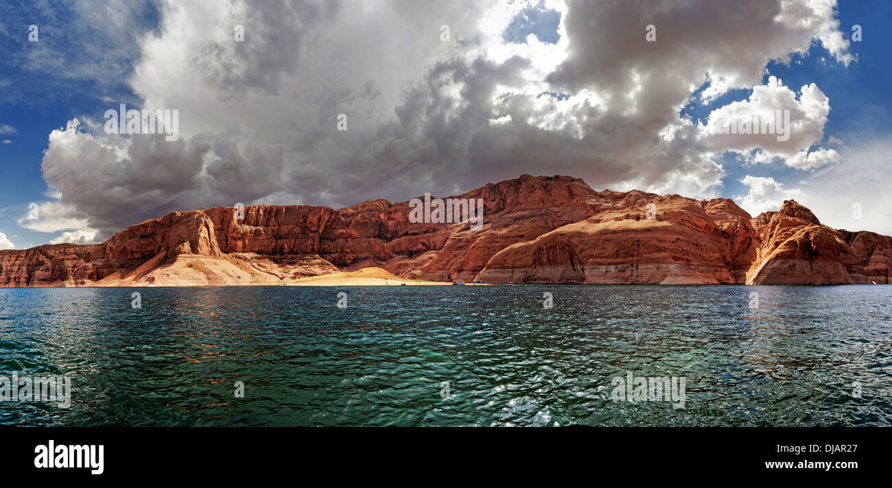 Red Navajo sandstone cliffs, rock formations, rising from Lake Powell ...