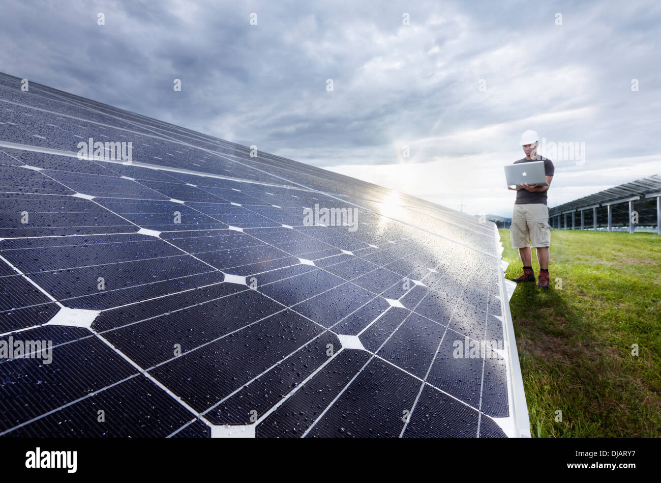 Solar installation technician checking solar panels with his laptop ...