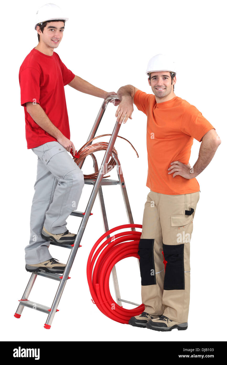 Two electricians with copper coil and ladder Stock Photo - Alamy