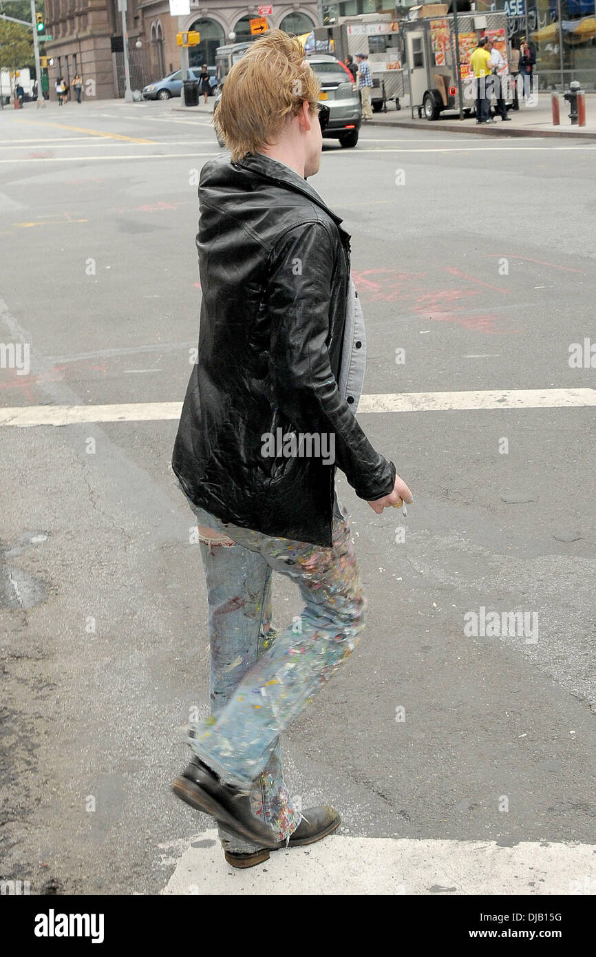 Macaulay Culkin wearing paint covered jeans, keeps his face hidden as ...