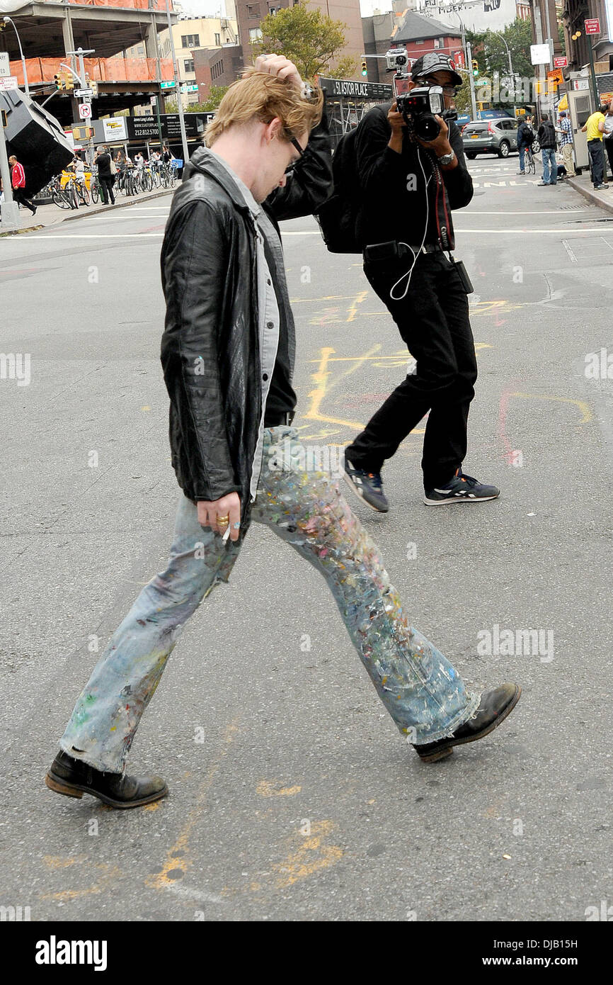 Macaulay Culkin wearing paint covered jeans, keeps his face hidden as ...
