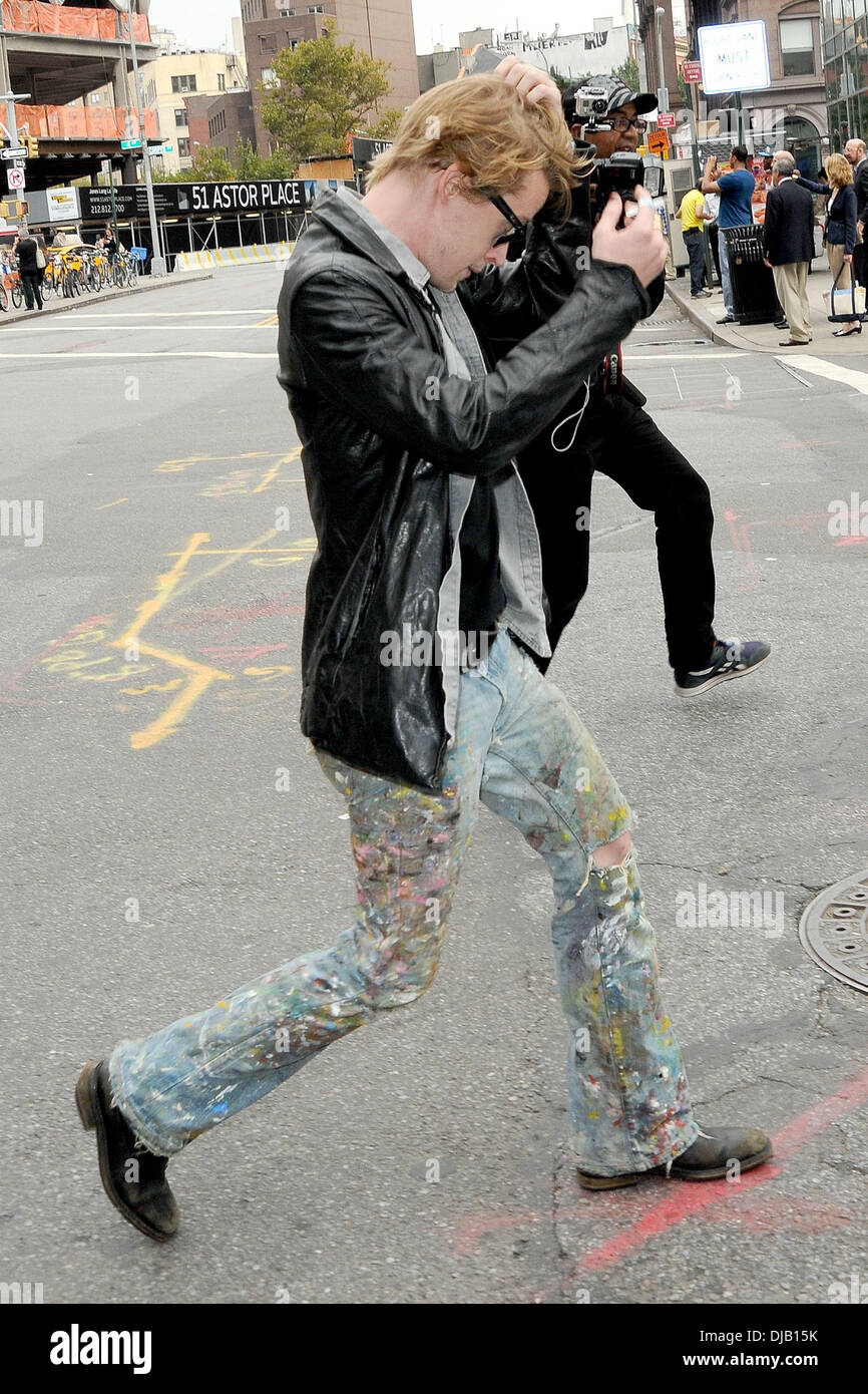 Macaulay Culkin wearing paint covered jeans, keeps his face hidden as ...