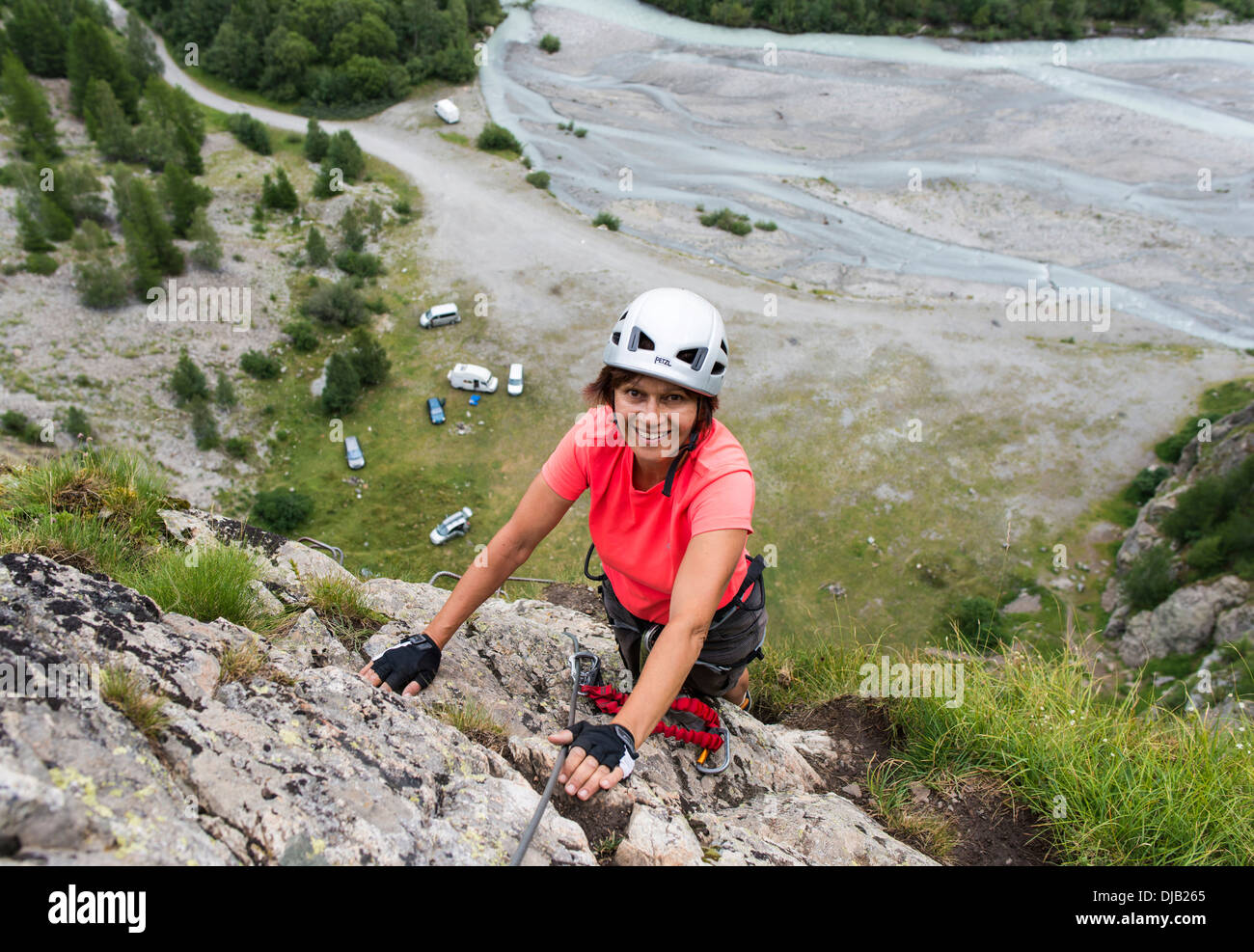 Female mountain climber climbing a fixed rope climbing route, Vallée de ...