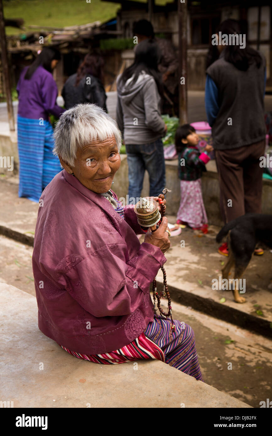 Bhutan, Nobding, old woman, wearing traditional clothing, spinning ...