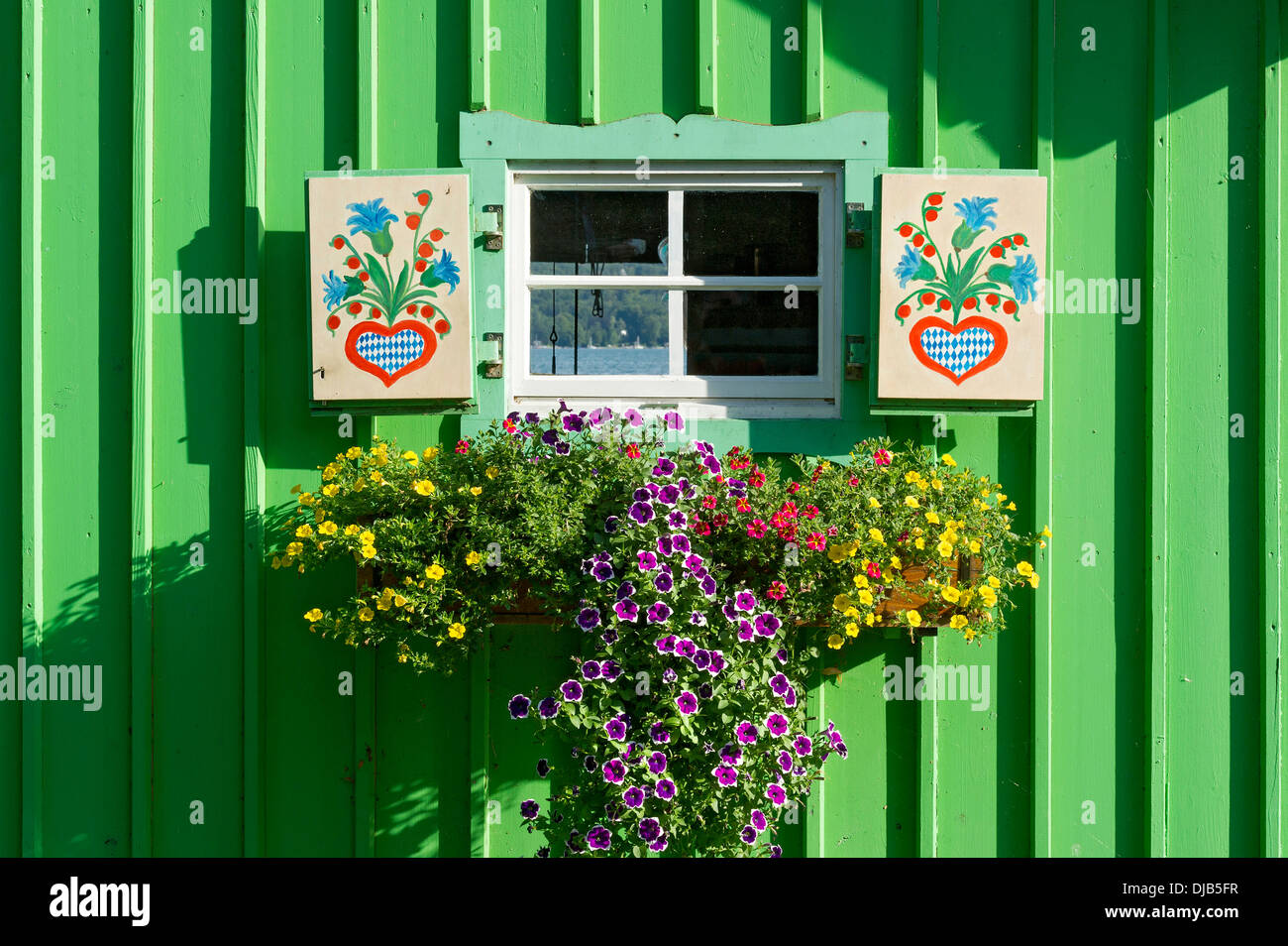 Window with painted shutters and flower box on green wooden hut, Lake ...