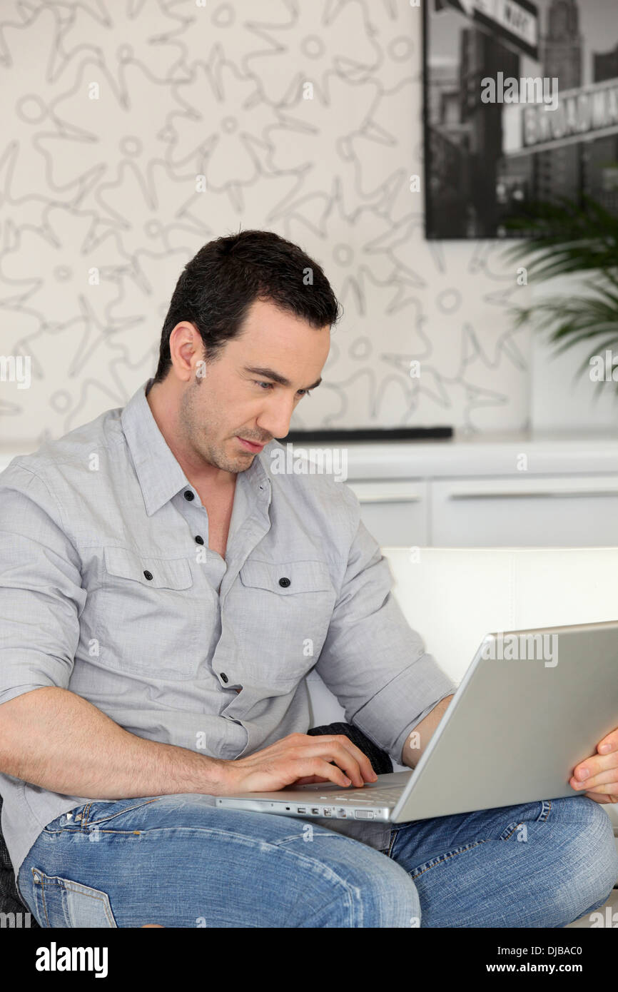 Man sitting on couch Stock Photo - Alamy