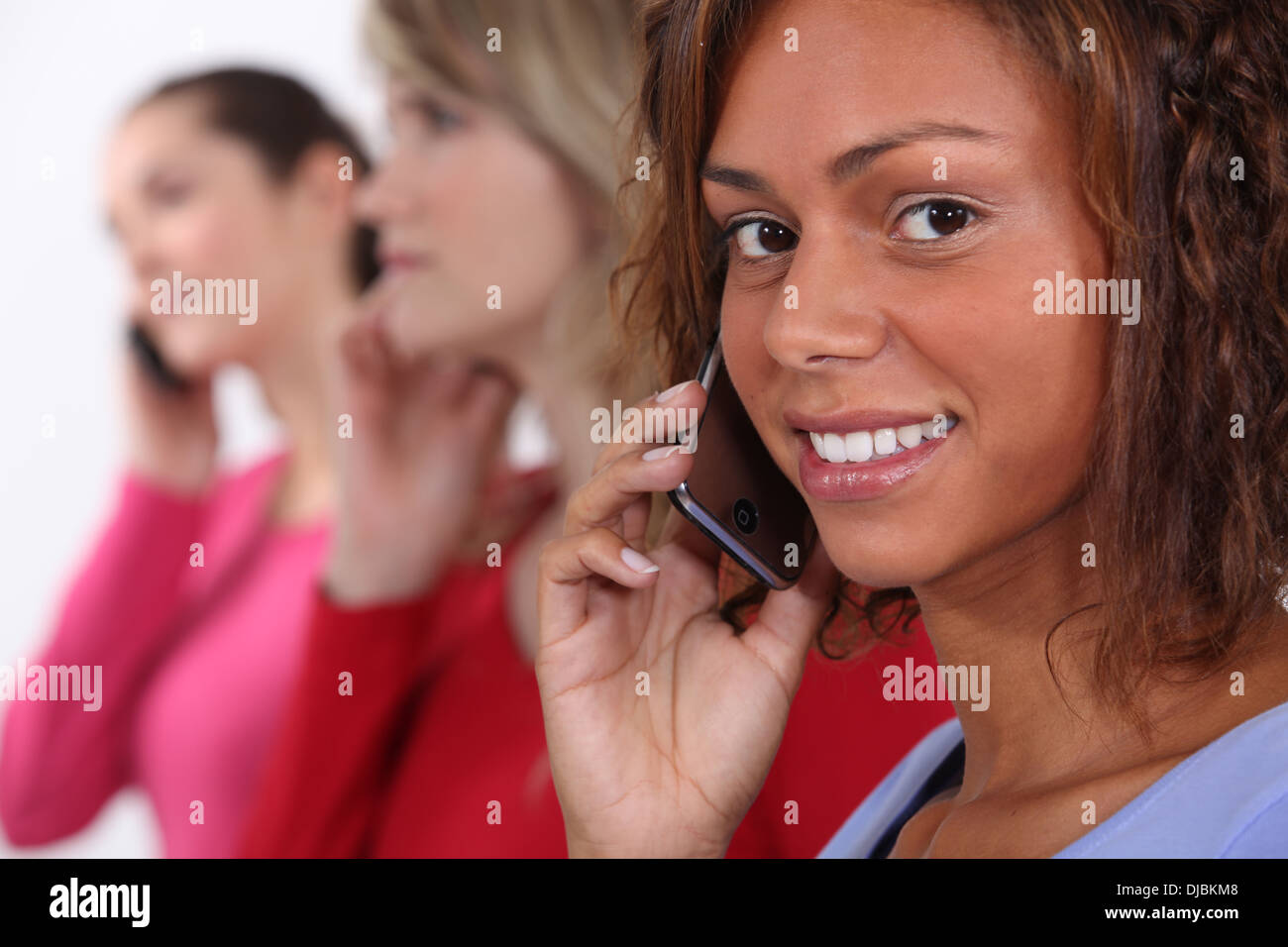 A row of women talking on their cellphones Stock Photo - Alamy