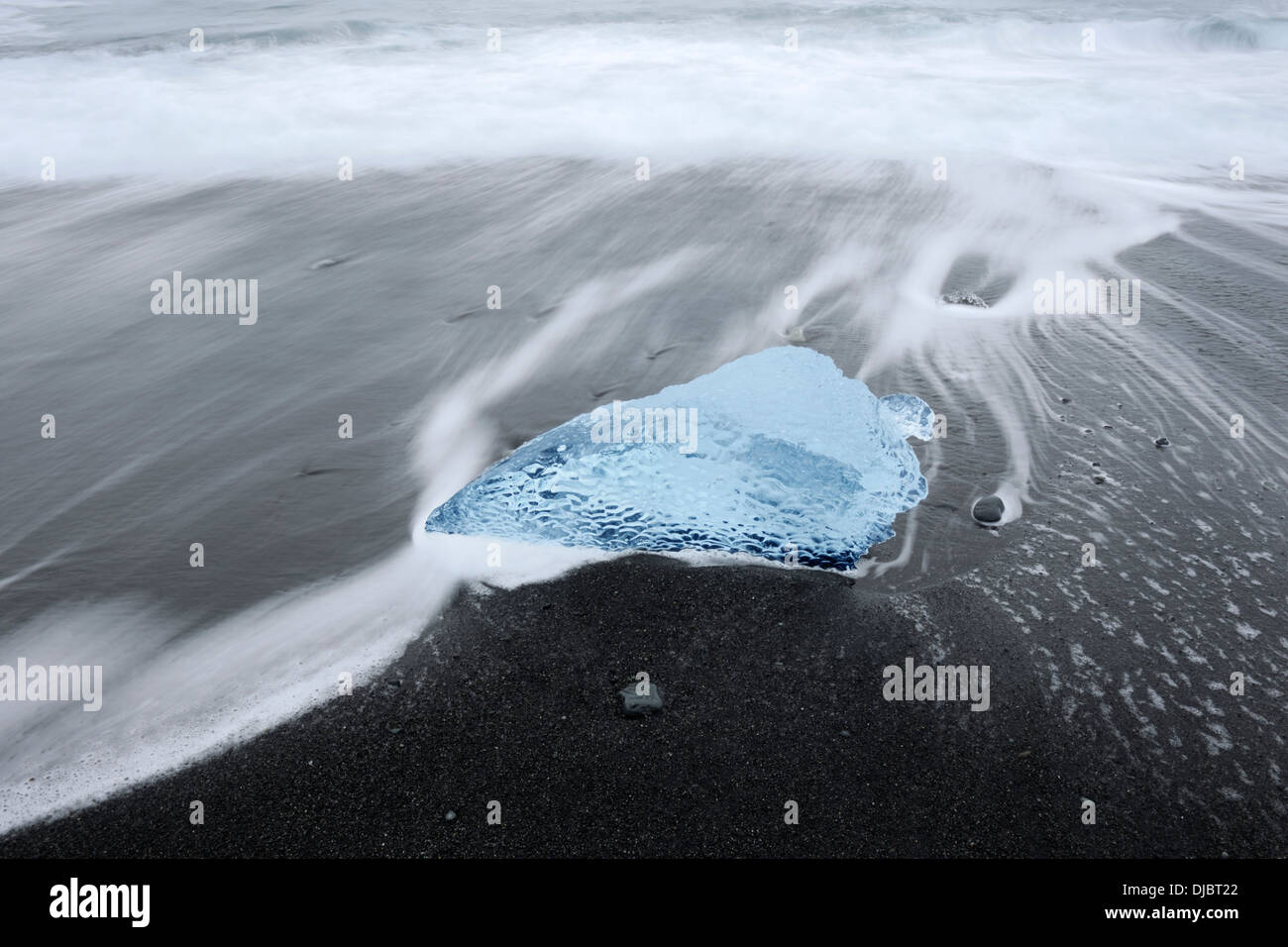 Ice block on a beach with lava stones and water floating over Stock ...