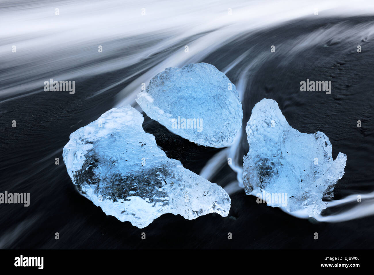 Ice blocks on a beach with lava stones and water floating over Stock ...