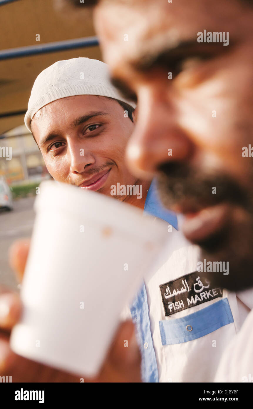 Arab workers at Deira Fish Market taking a coffee break and watching ...