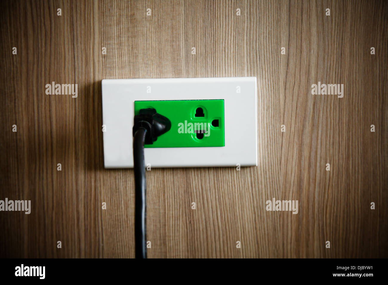 Green electrical outlet on a wood wall Stock Photo - Alamy
