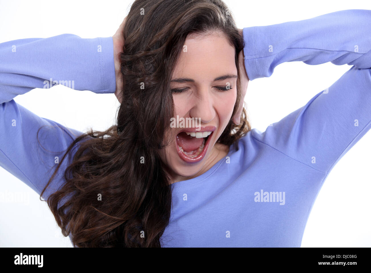 young woman plugging her ears and screaming Stock Photo - Alamy