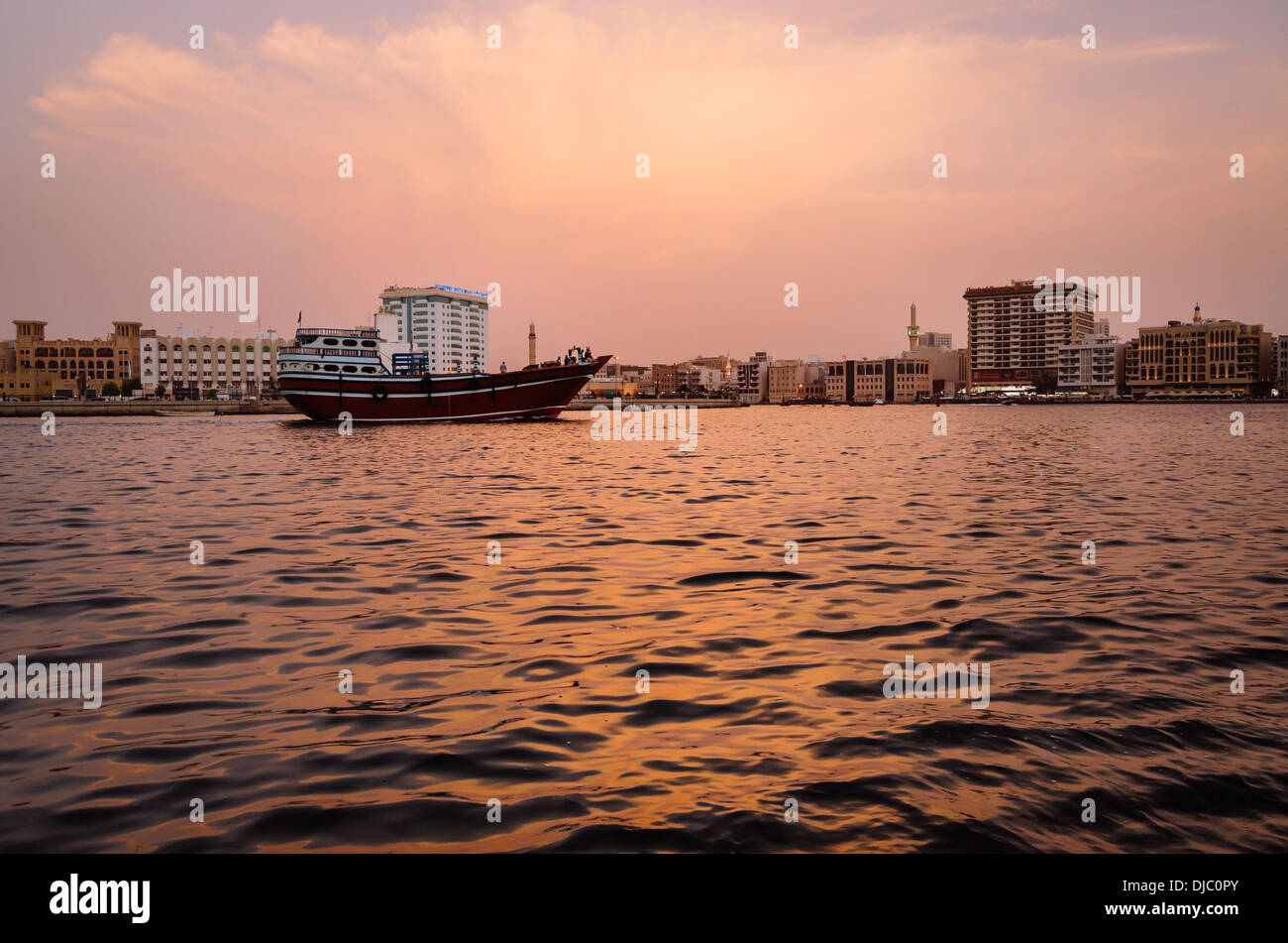 A traditional Arab dhow boat cruising the waters of Dubai Creek during ...