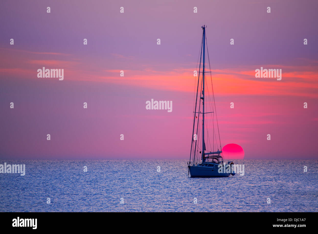 Ibiza sunset sun view from formentera Island with sailboat in Balearic ...