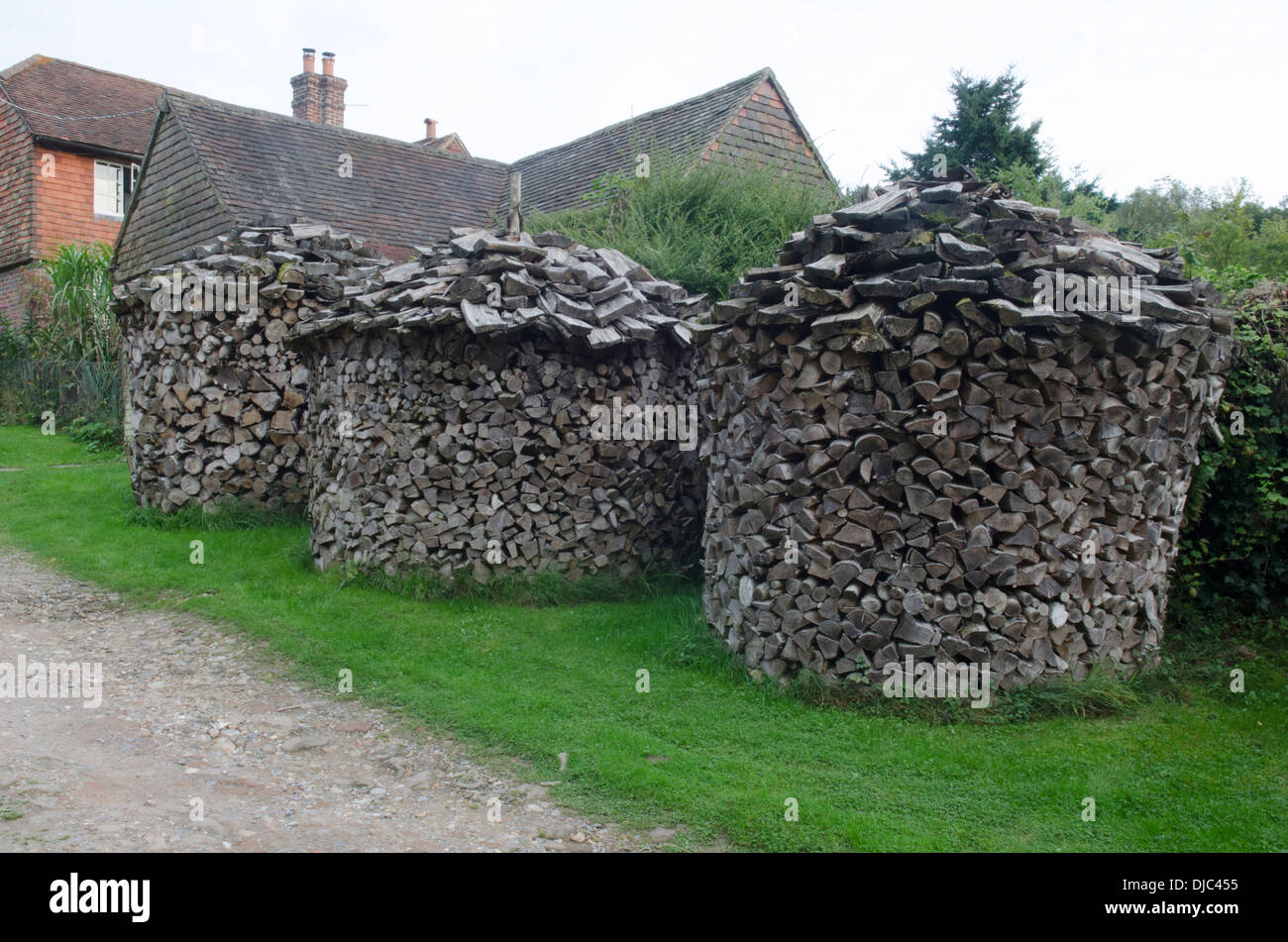 pile of wood logs for fire UK stacked in domed structures, Sussex, UK ...