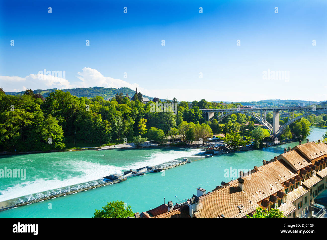 Aare river in Bern with dam and bridge behind the red houses roofs ...
