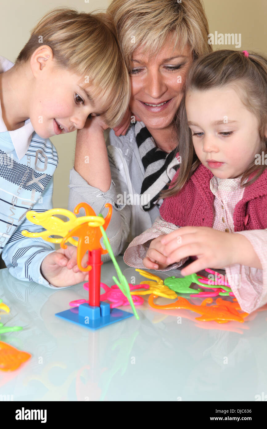Mother and children playing a game Stock Photo - Alamy