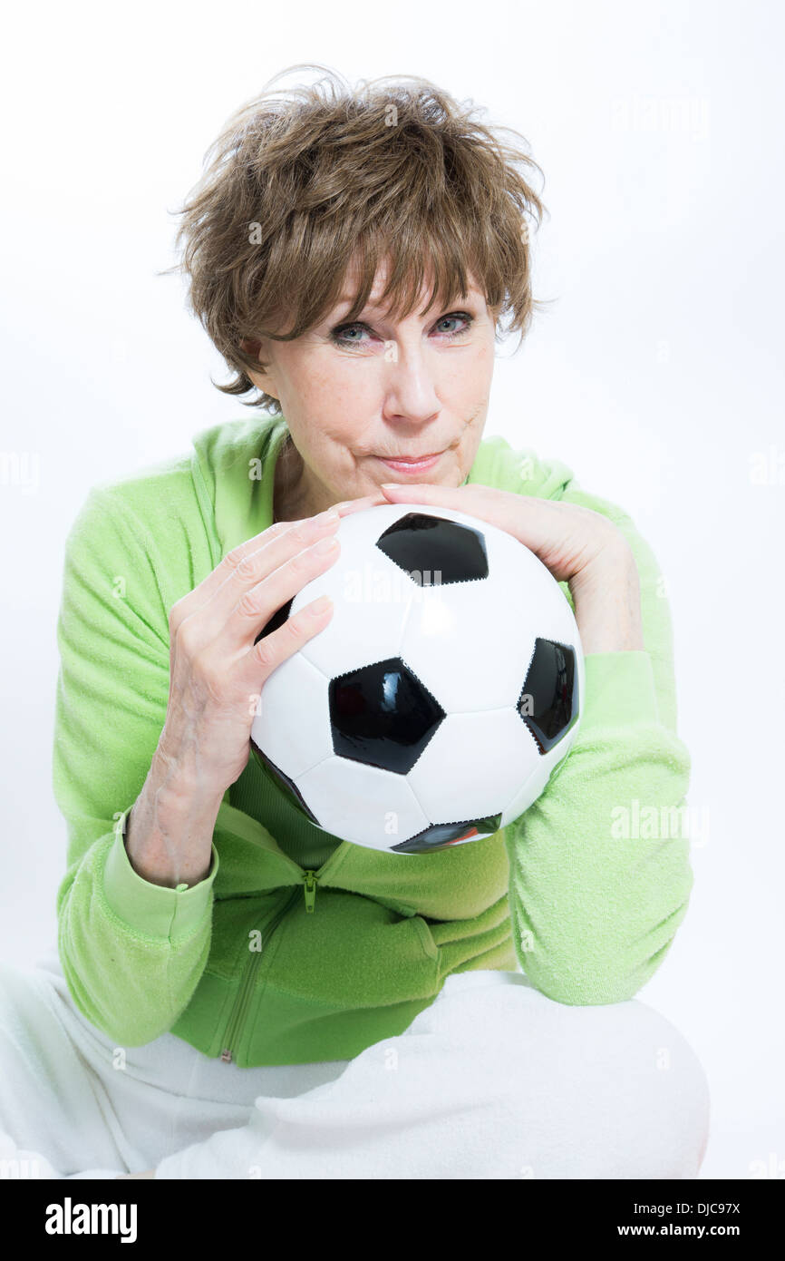 Mature woman holding soccer ball Stock Photo - Alamy
