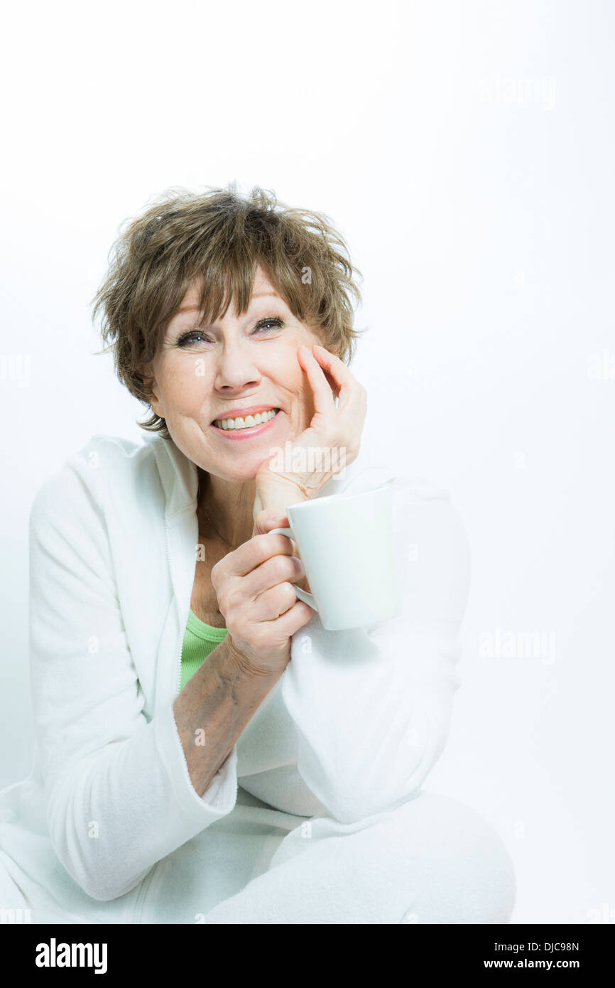 Smiling mature woman holding white mug Stock Photo - Alamy