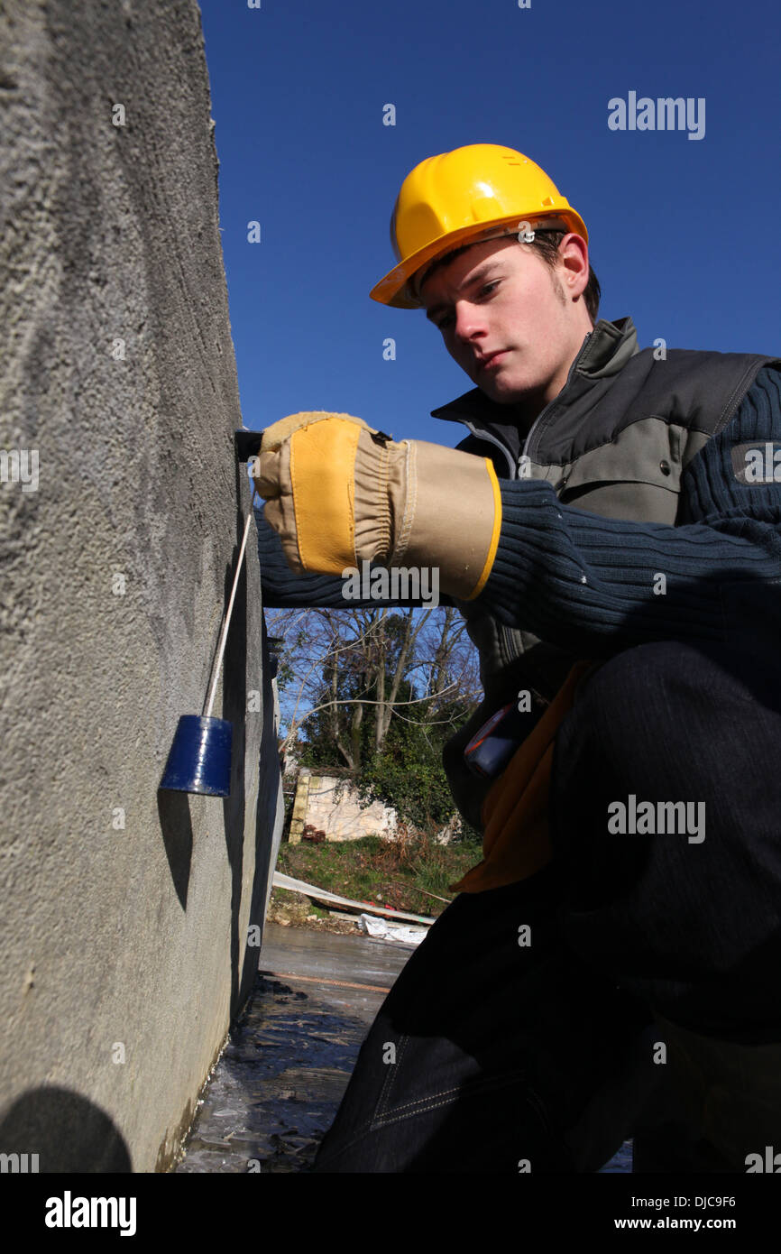 Tradesman using a tool Stock Photo - Alamy