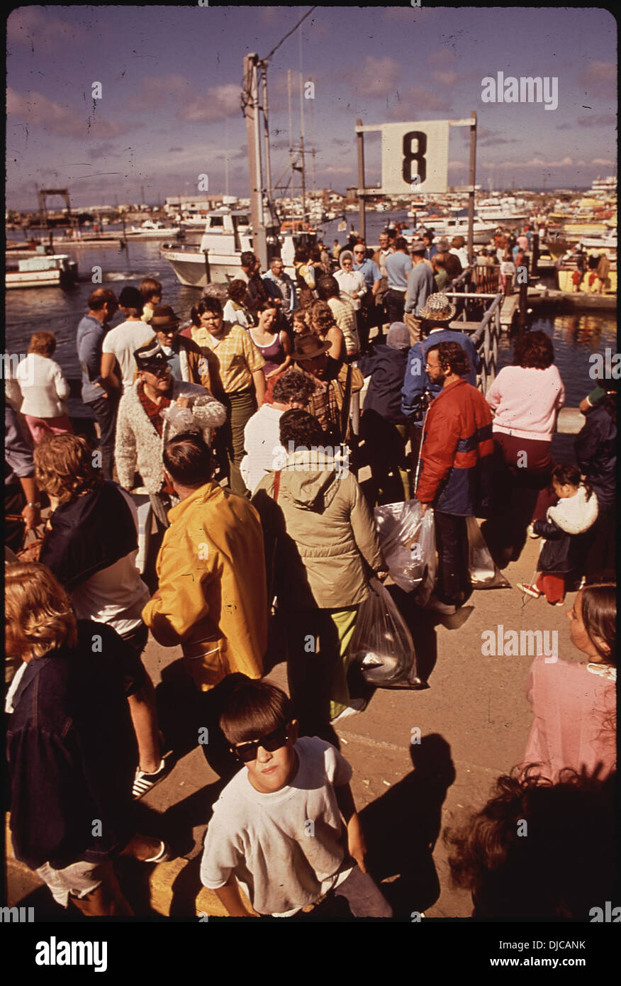 A crowd of individuals is seen returning from a salmon fishing trip ...