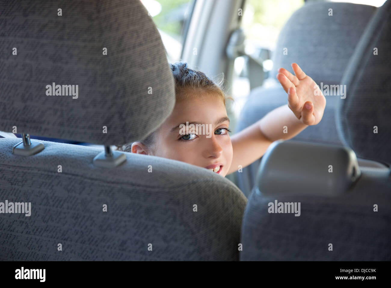 Kid children girl happy greeting gesture hand in car vehicle indoor ...