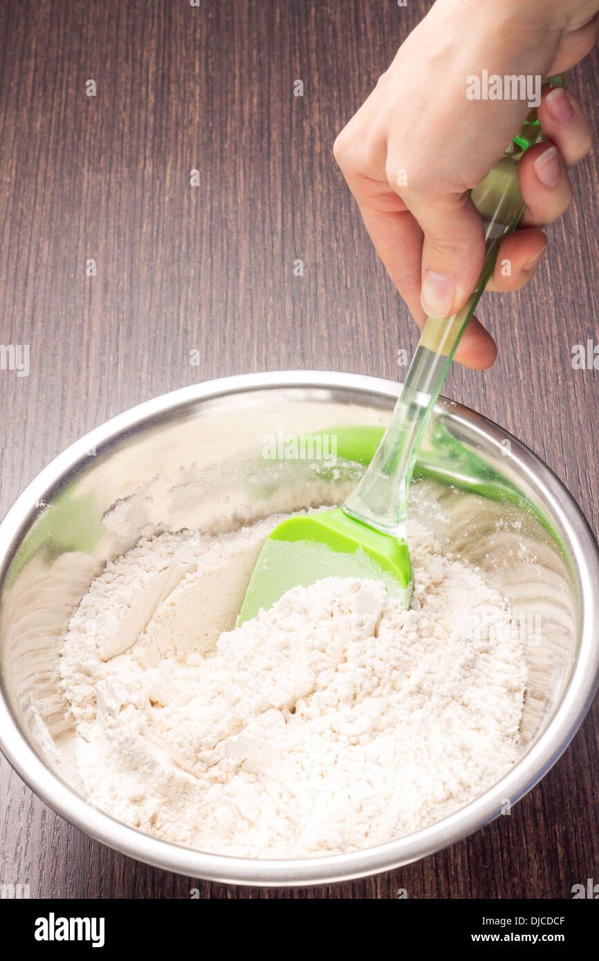 Mixing wheat flour in metallic bowl on table Stock Photo - Alamy