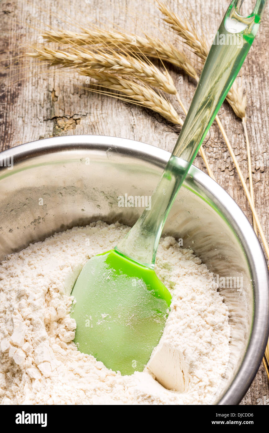 Mixing wheat flour in metallic bowl on wood background Stock Photo - Alamy