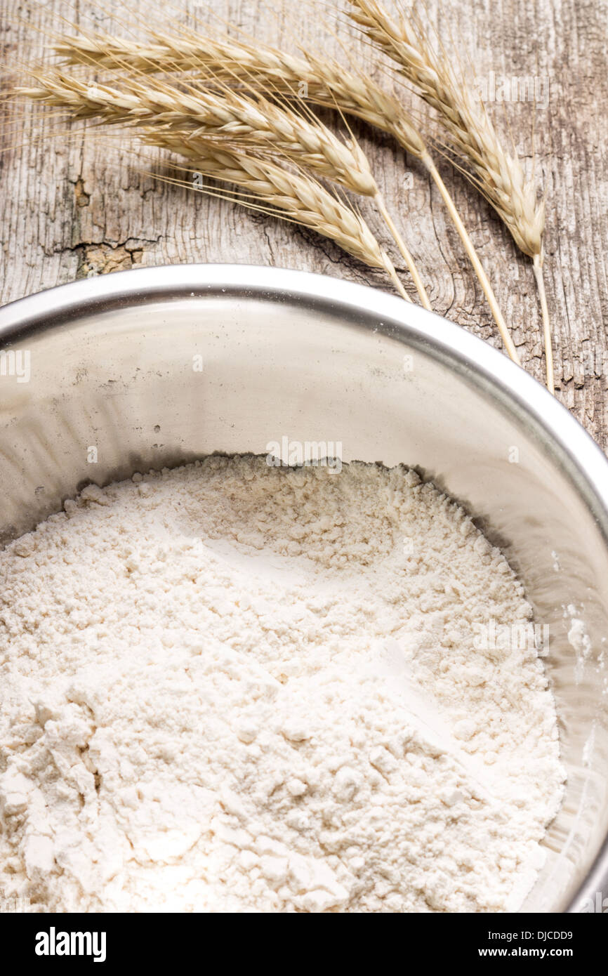 Mixing wheat flour in metallic bowl on wood background Stock Photo - Alamy