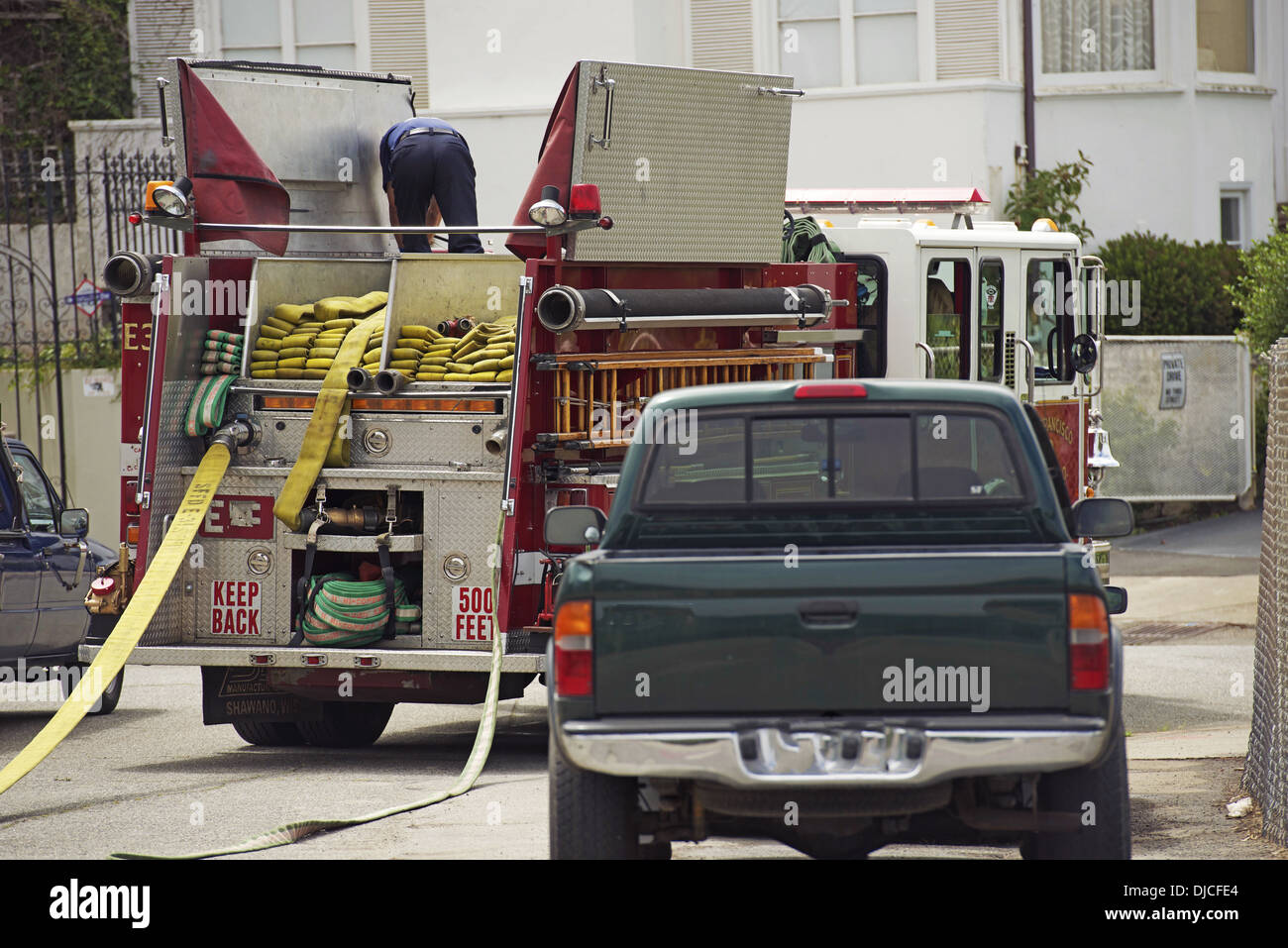 Firefighters in Action - Fire Truck on the Residential Road. Public ...