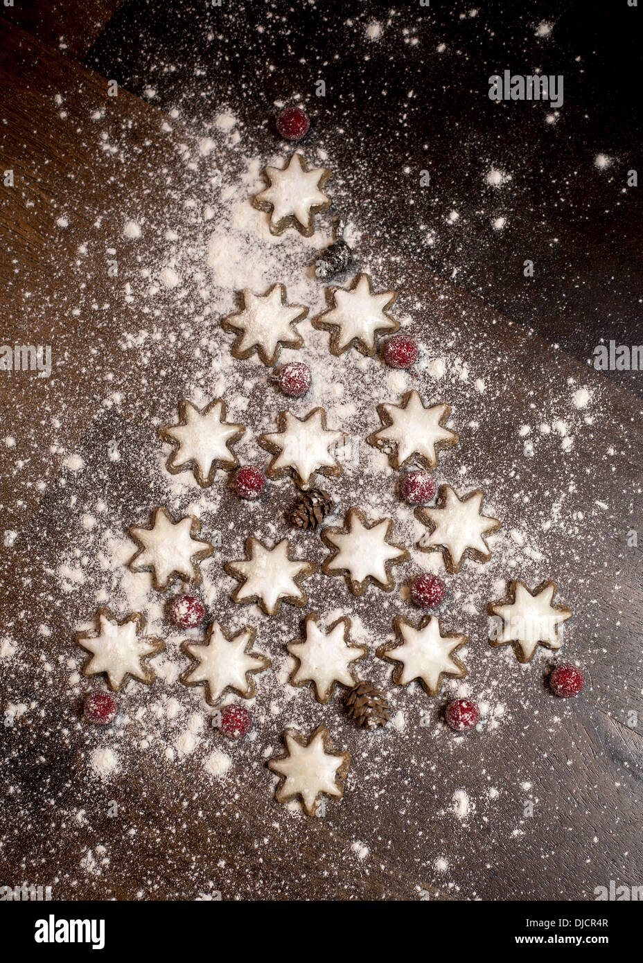 Christmas tree formed of star-shaped cinnamon cookies, red berries and ...