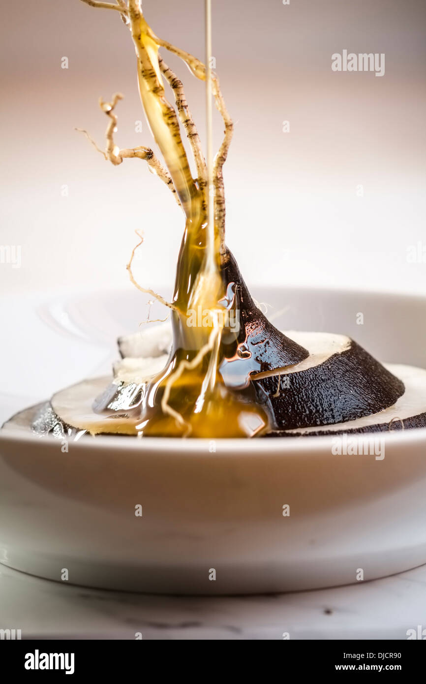 Sliced black radish (Raphanus sativus) with dropping honey, studio shot ...