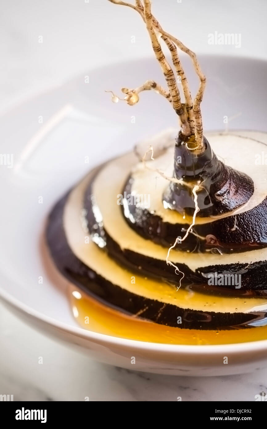 Sliced black radish (Raphanus sativus) with honey, studio shot Stock ...