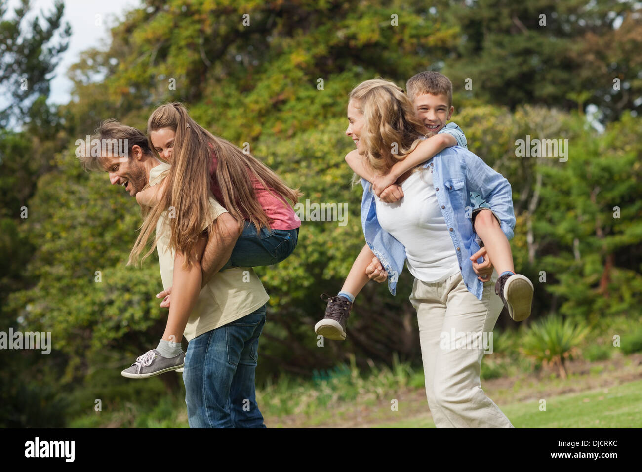 Parents carrying their children on their back Stock Photo - Alamy