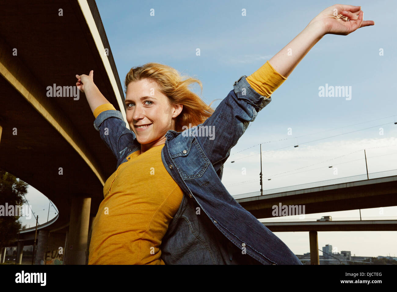 Germany, Dusseldorf, Young woman raising arms Stock Photo - Alamy
