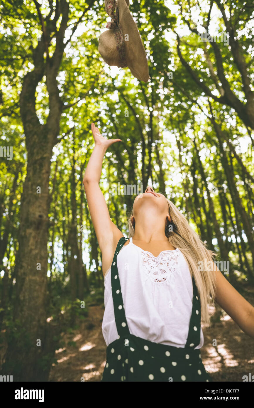 Happy gorgeous blonde throwing straw hat in the air Stock Photo - Alamy