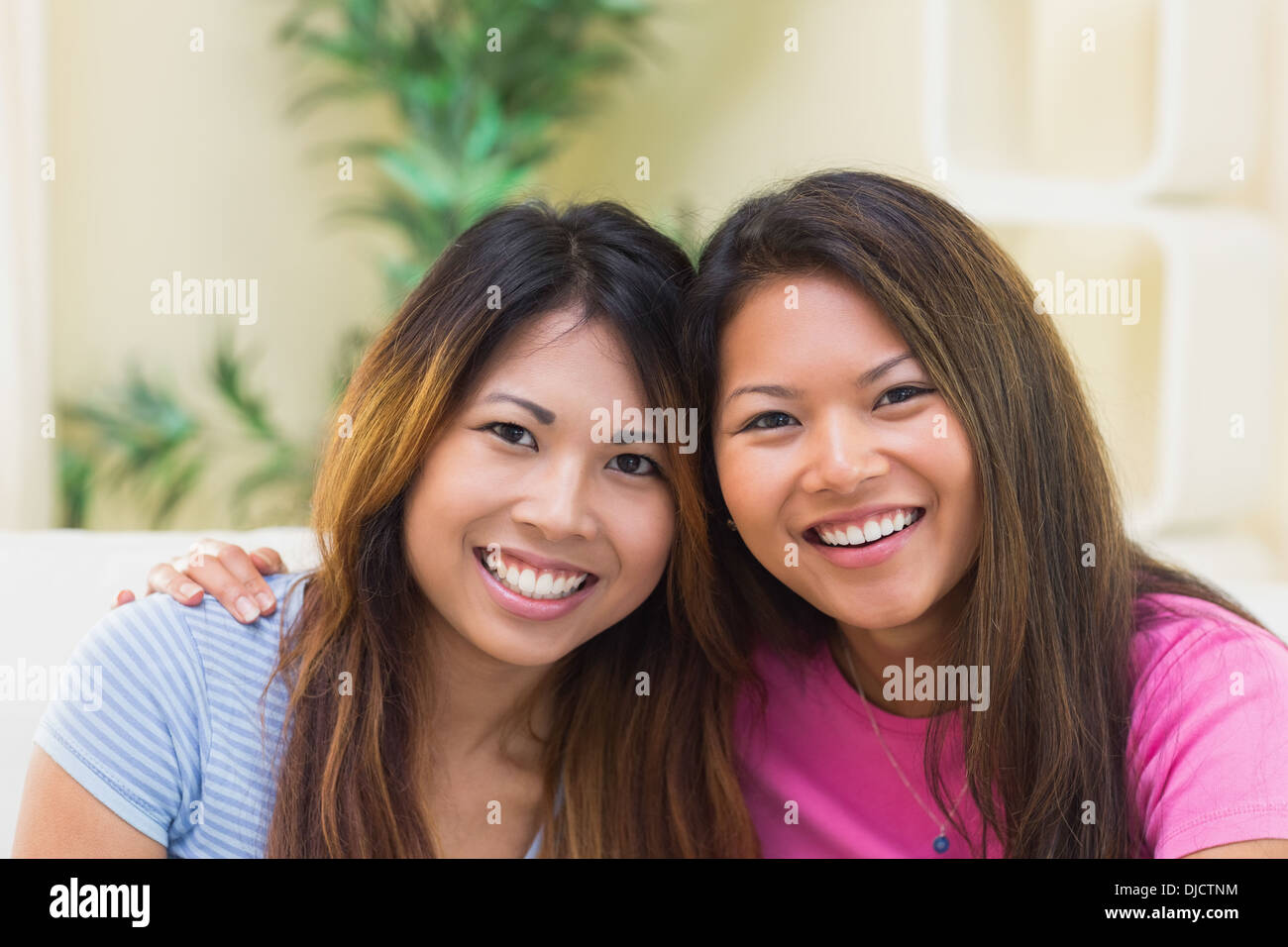 Two young sisters smiling at the camera Stock Photo - Alamy