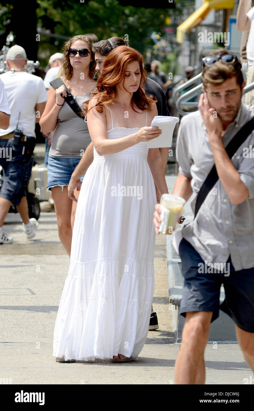 Debra Messing wearing a long white dress during filming for the TV show ...