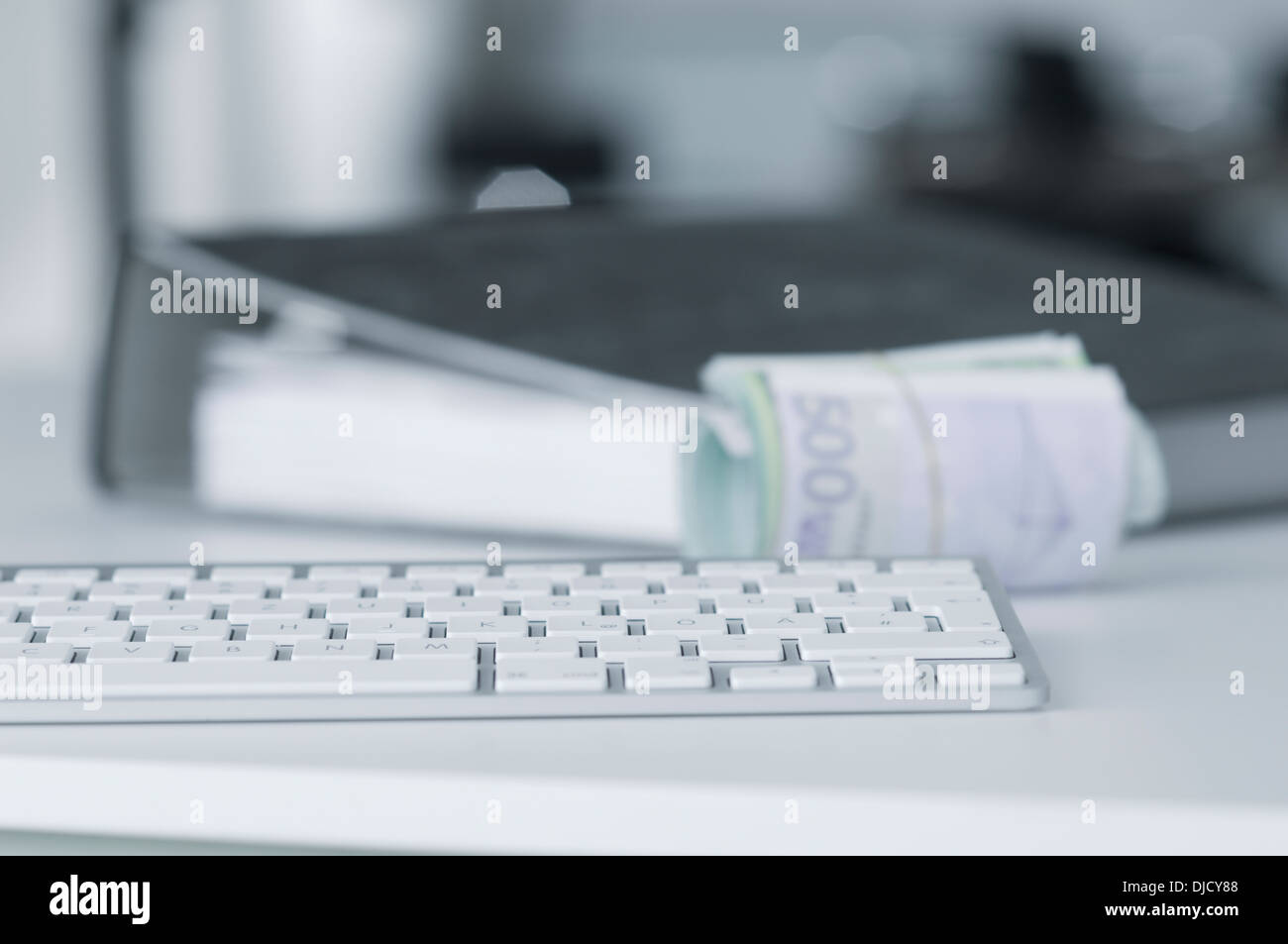 Keyboard on desk, folder and money Stock Photo - Alamy