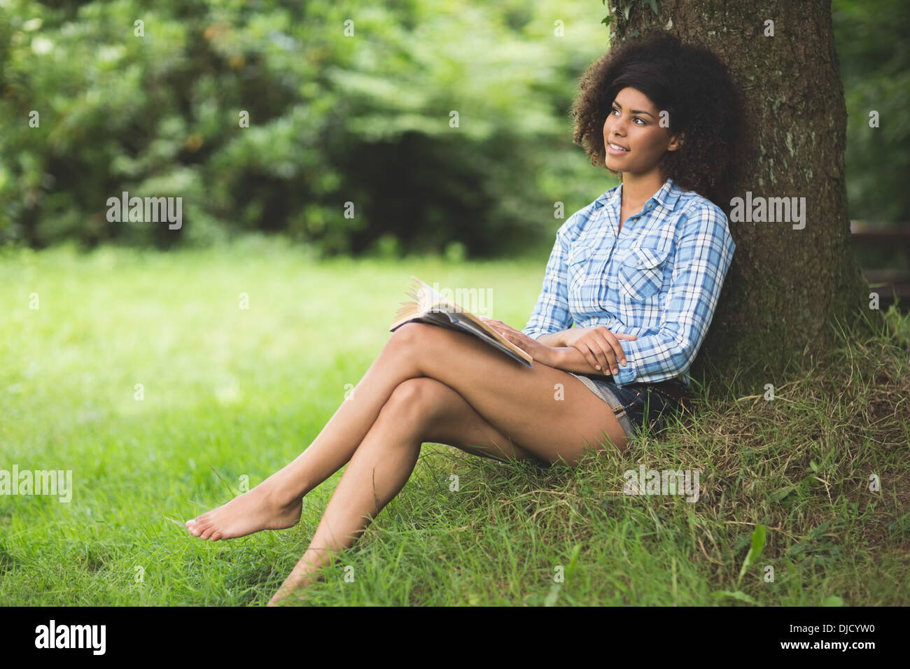 Woman sitting against tree trunk hi-res stock photography and images ...