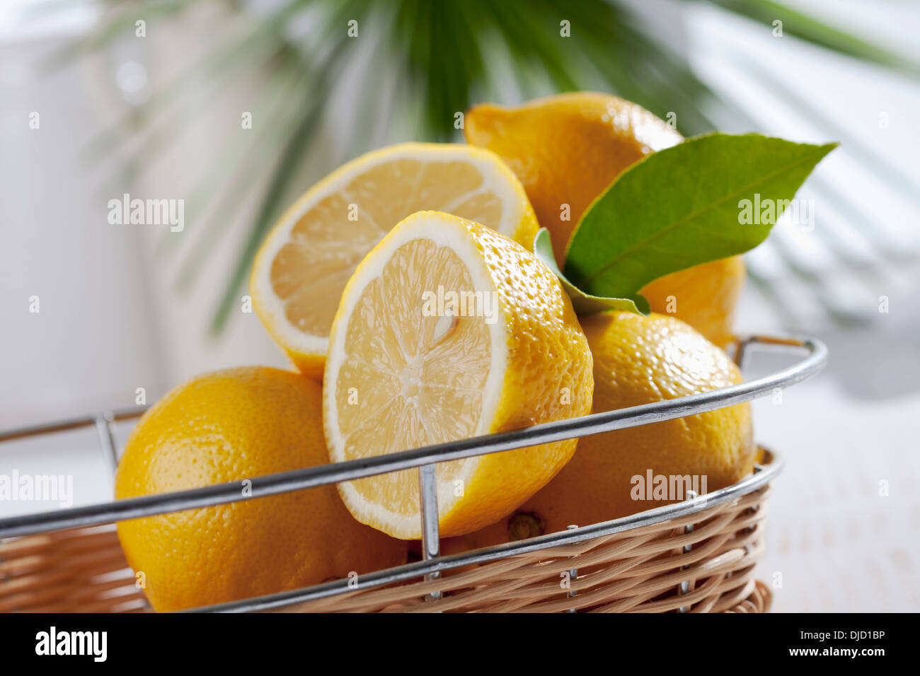 Sliced and whole lemons in basket, studio shot Stock Photo - Alamy