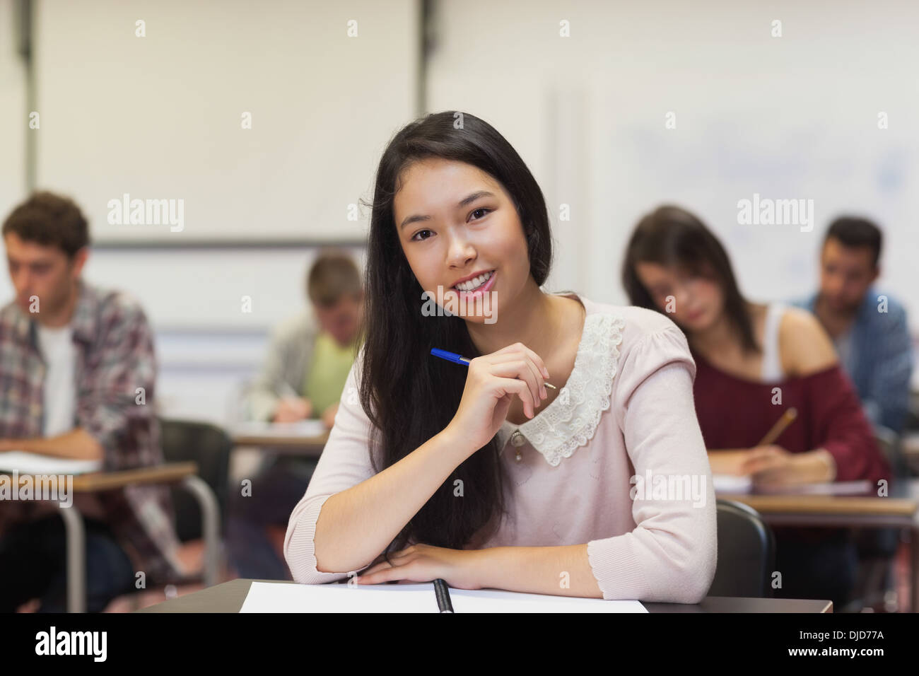 Focused asian student smiling at camera in class Stock Photo - Alamy