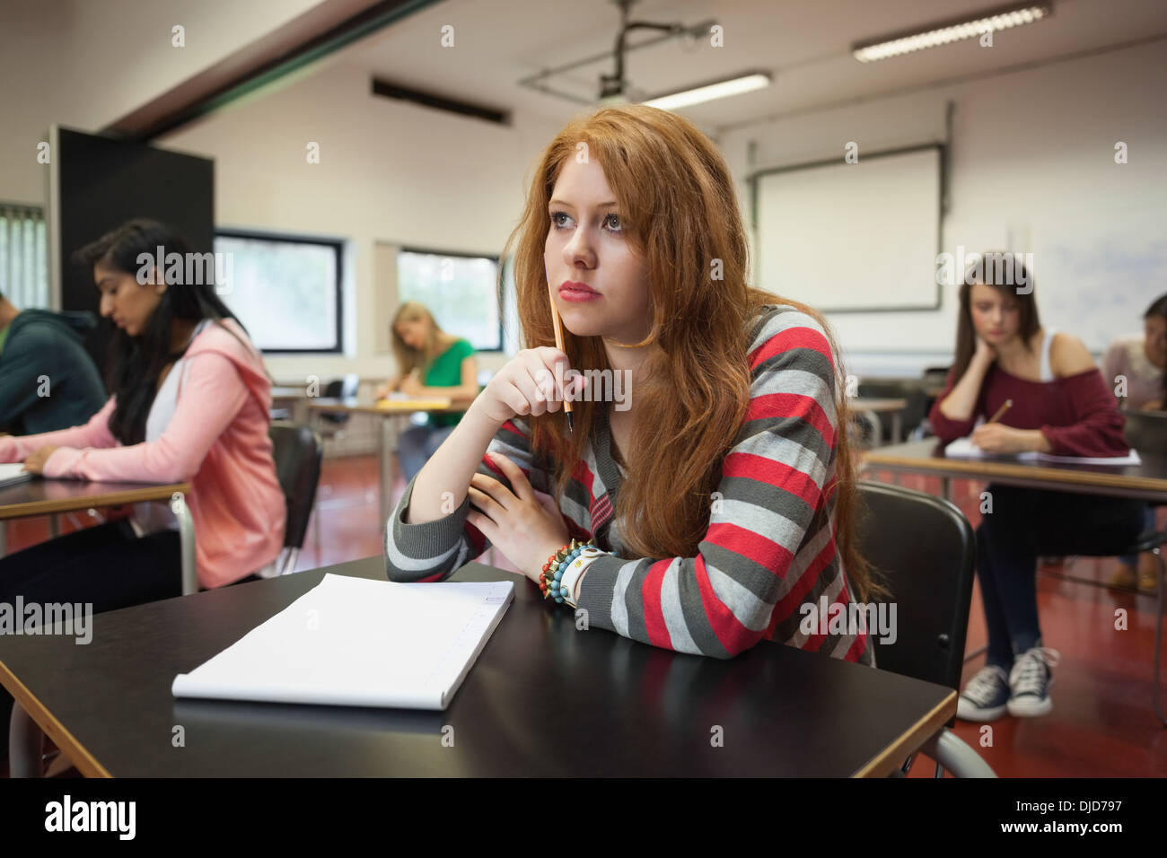Bored female student listening in class Stock Photo - Alamy
