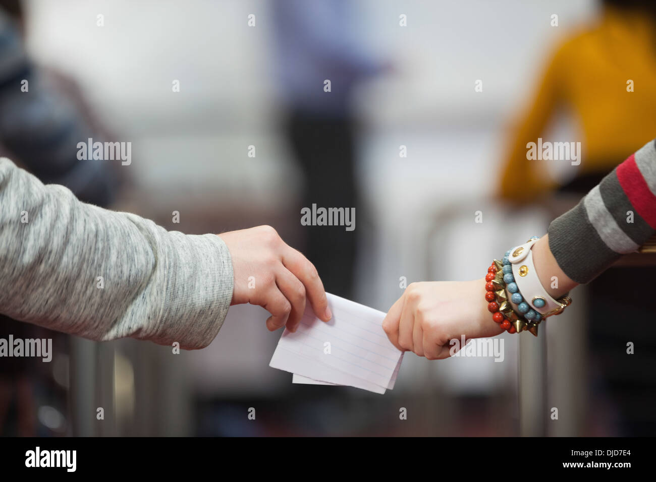 Students passing notes in classroom Stock Photo - Alamy