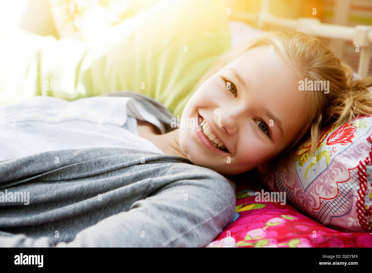 Smiling girl lying on bed, portrait Stock Photo - Alamy