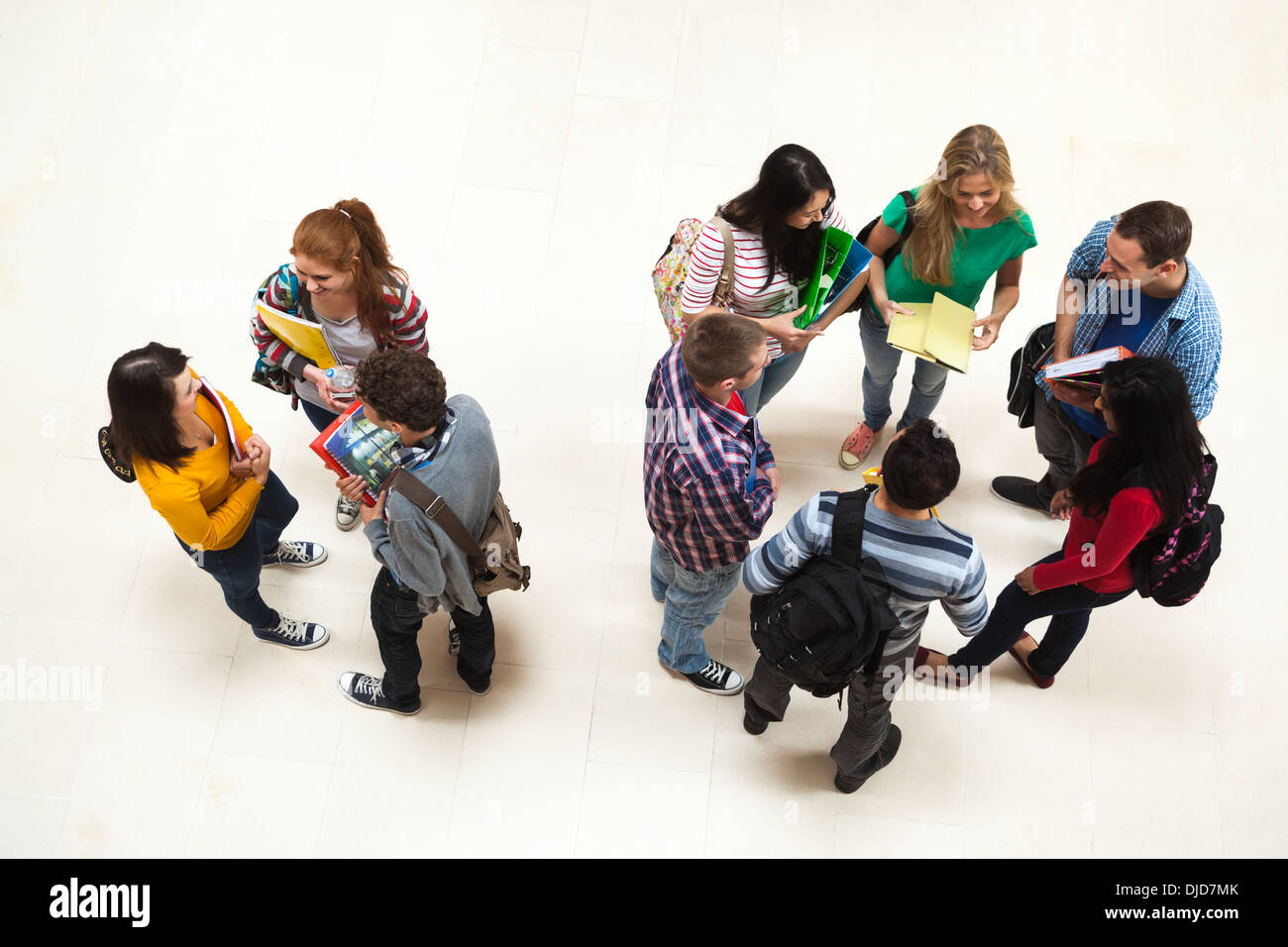 Happy students chatting together in a hall Stock Photo - Alamy
